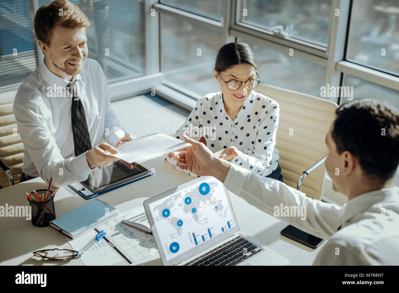 Smiling boss handing copies of documents before meeting Stock Photo - Alamy