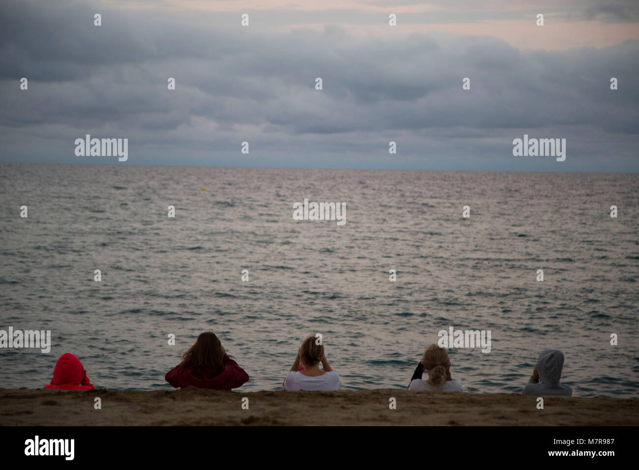 In October of 2017 several women do yoga before nightfall on the beach ...