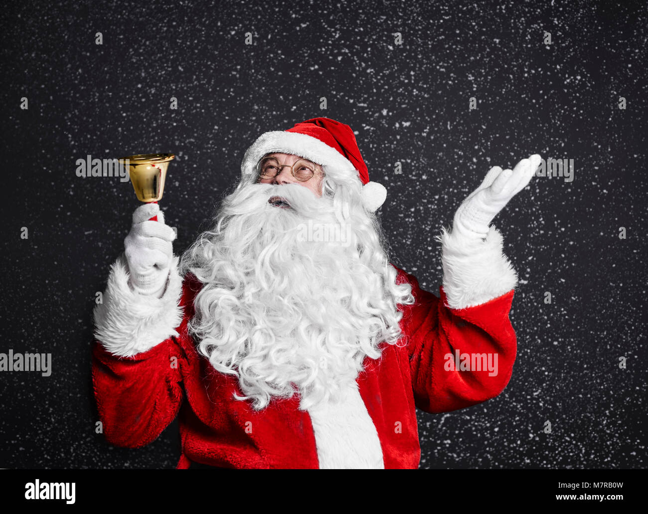Santa claus with handbell among snow falling Stock Photo - Alamy
