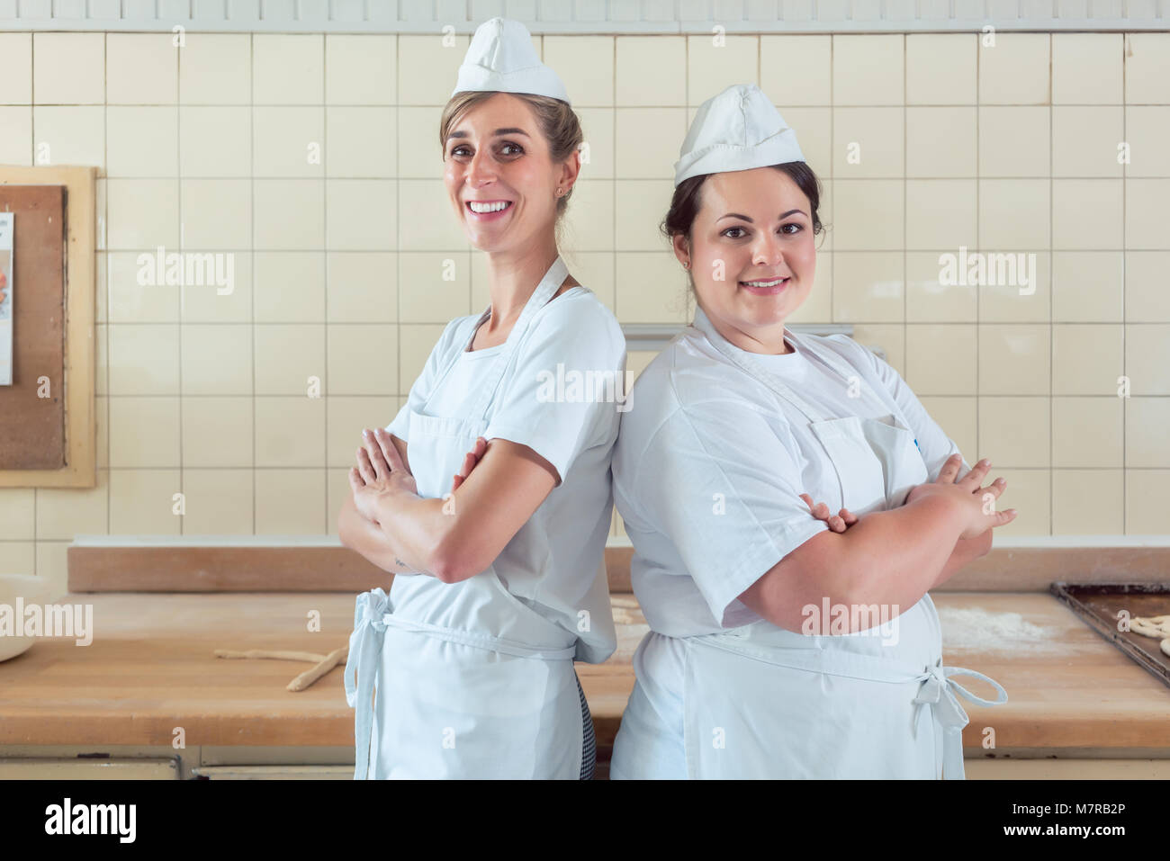 Two baker women standing proud in their bakery Stock Photo - Alamy