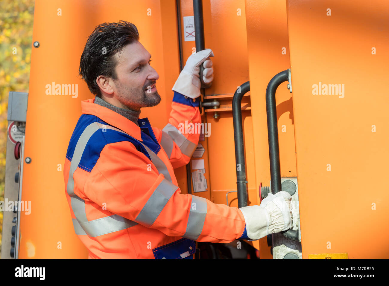 Waste collector gripping handle of garbage truck Stock Photo - Alamy