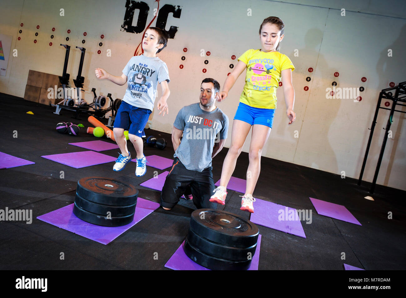 a young boy and girl jumping on and off a platform during a keep fit ...