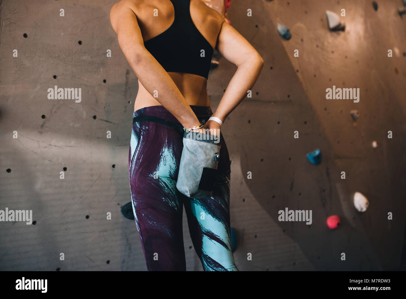 Rear view of woman at applying magnesium chalk powder on hands from a ...