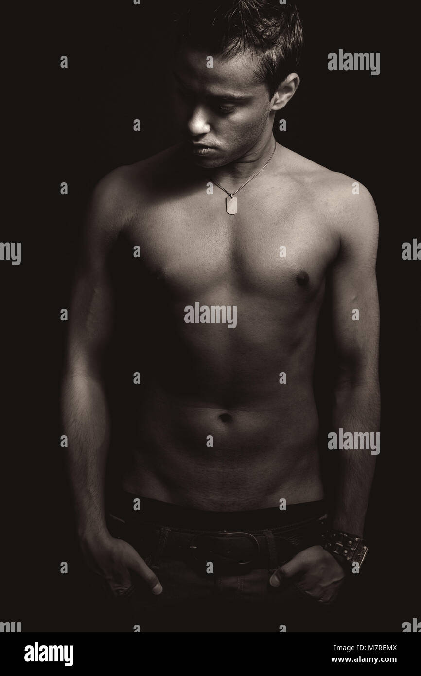 Sexy shirtless young male model posing fashion over dark background ...