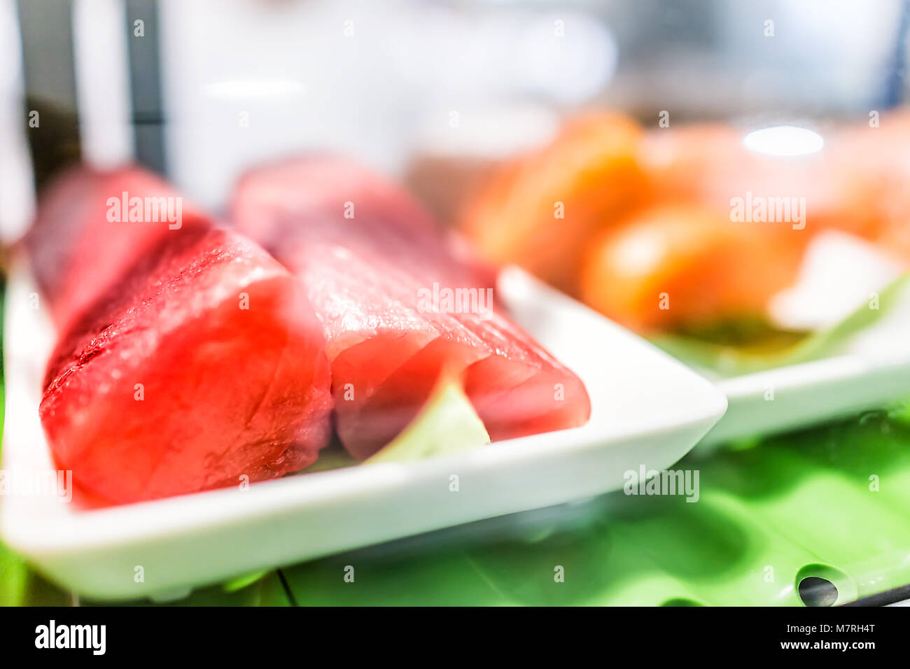 Seafood stand with cuts of red pink farmed wild tuna steaks on tray ...