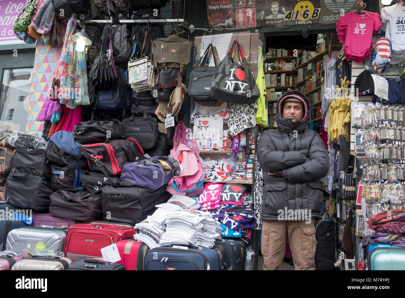 A merchant stands in front of his store that caters primarily to ...