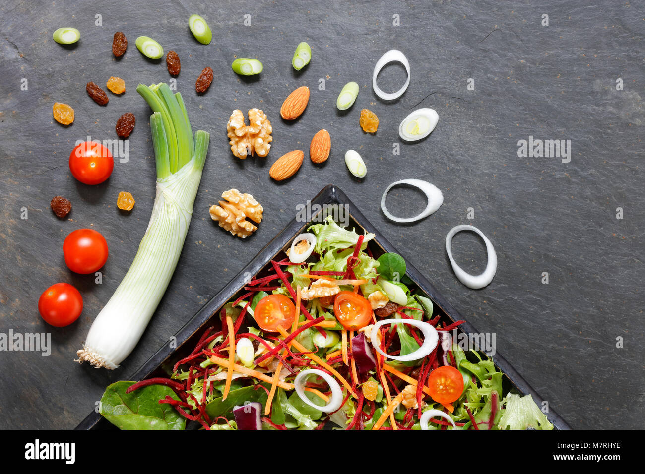 Salad ingredients with lettuce, cabbage, nuts and seeds on slate from ...