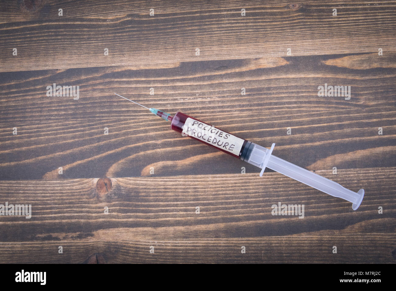 policies and procedure concept. Medicine syringe with liquid inside and ...