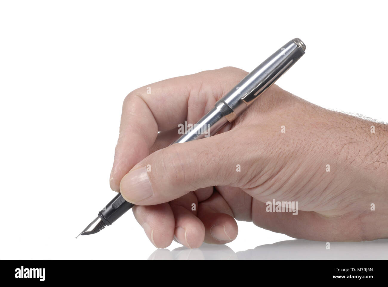 Stainless steel classic fountain pen held in a writing position by a ...