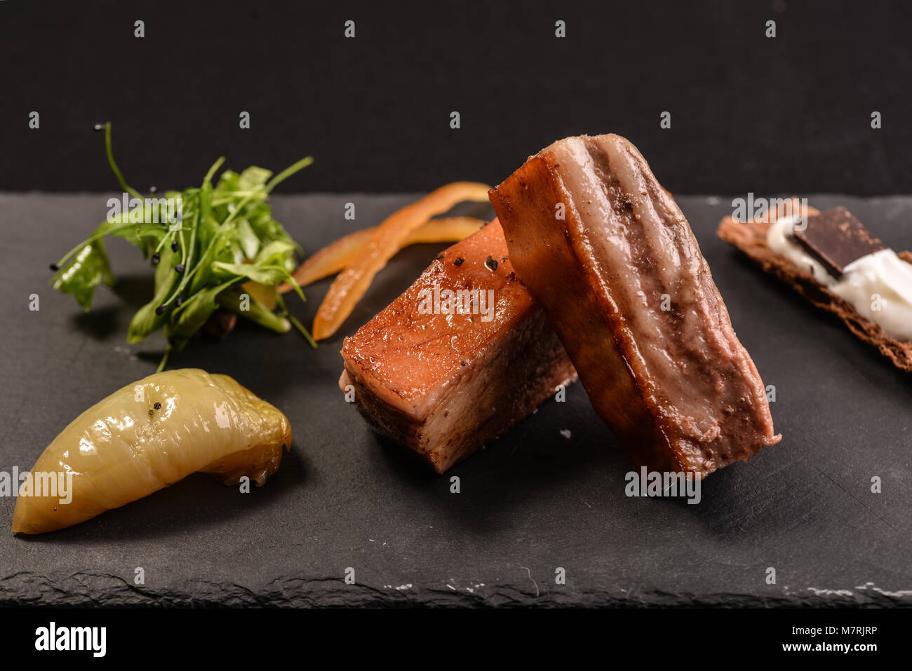 Black pig with candied orange and cannolo Stock Photo - Alamy