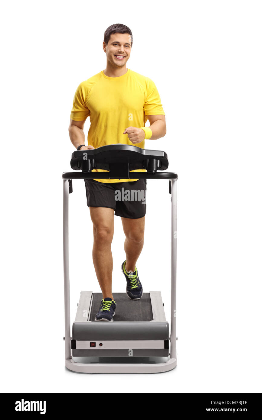 Full length portrait of a guy running on a treadmill isolated on white ...