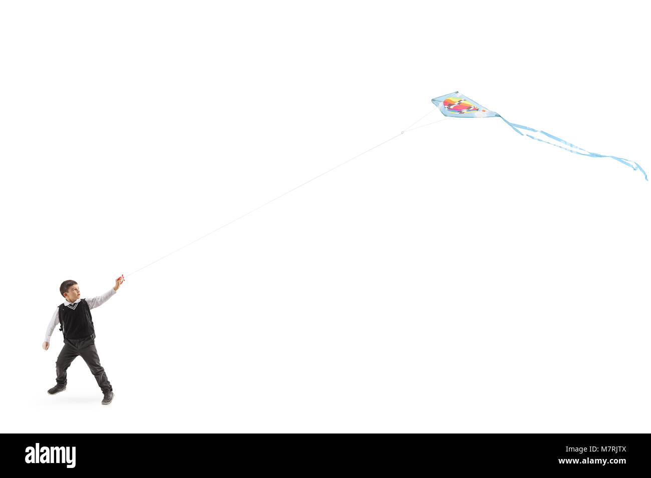 Full length profile shot of a schoolboy flying a kite isolated on white ...