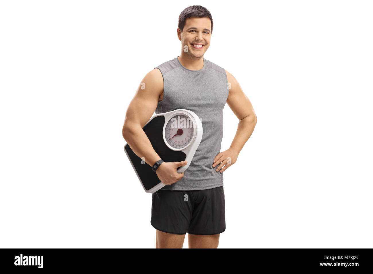 Young man in sportswear holding a weight scale isolated on white ...