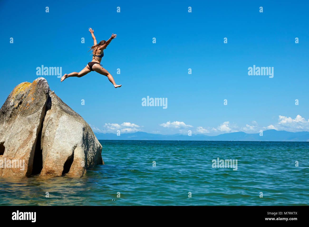 Girl jumping off rock, Mosquito Bay, Abel Tasman National Park, Nelson ...