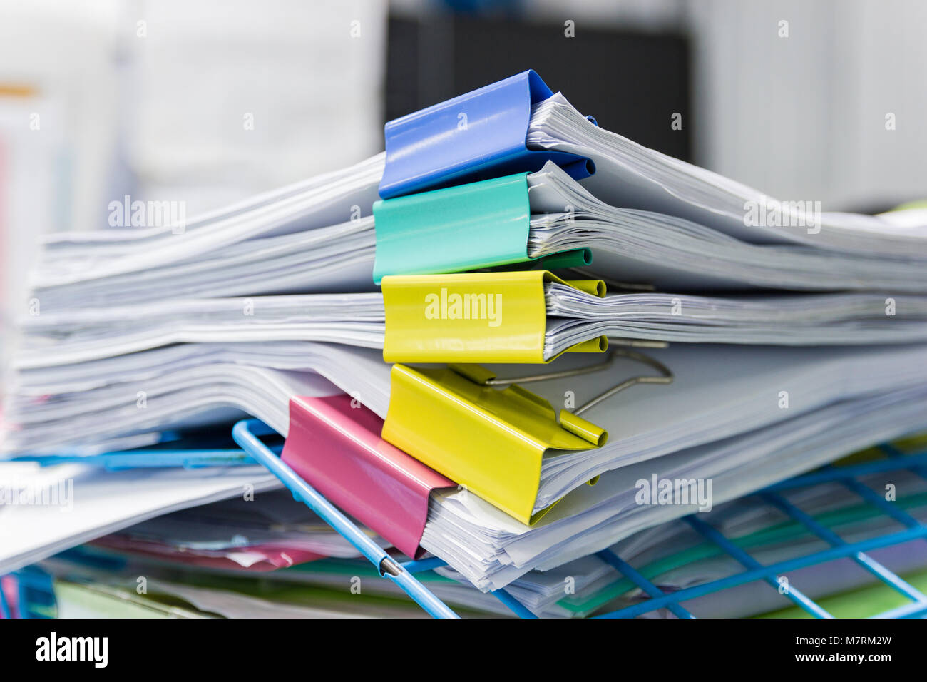 Stack of papers documents in archives files with paper clips on desk at ...