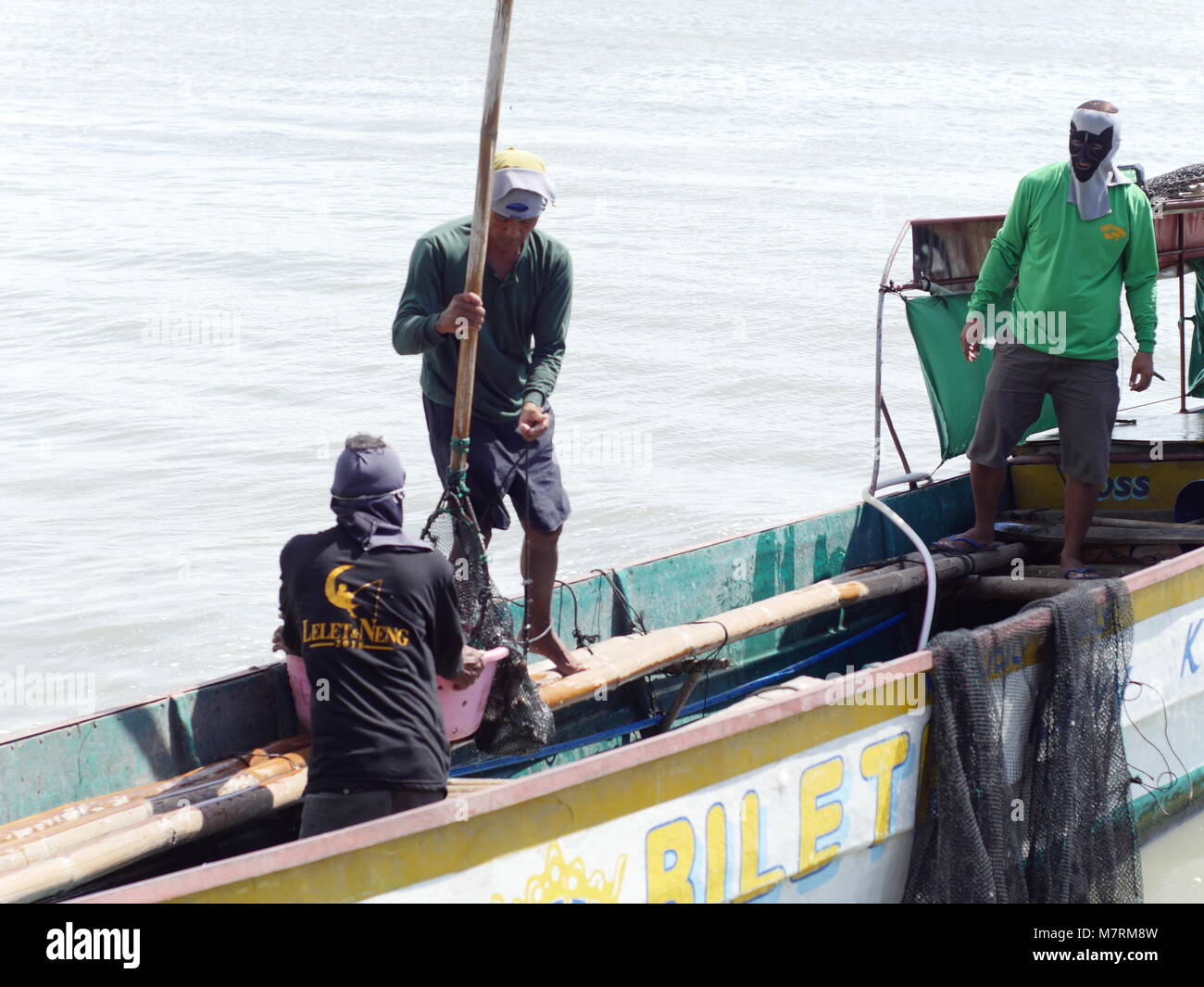 These fishermen, wearing mask to protect from harsh sunlight, are ...