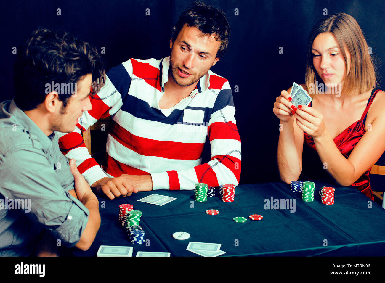 young people playing poker on black background Stock Photo - Alamy