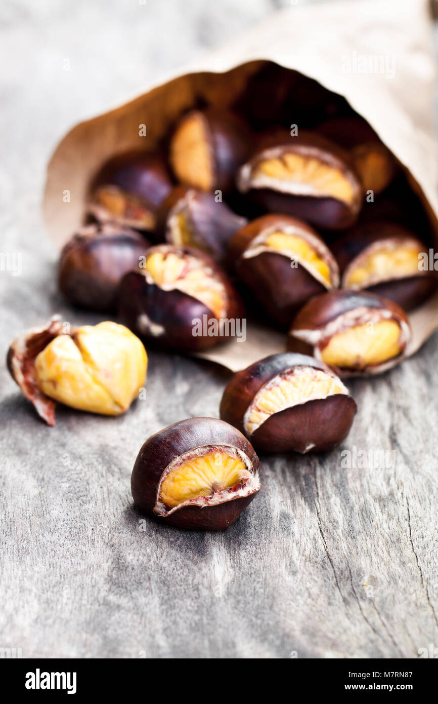 Roasted chestnuts on wooden background Stock Photo - Alamy