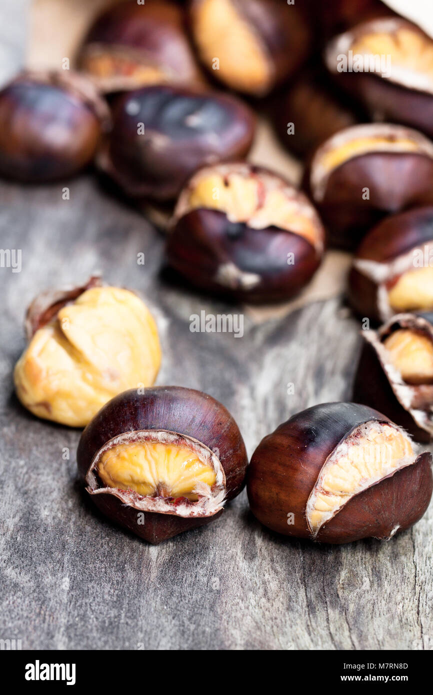 Roasted chestnuts on wooden background Stock Photo - Alamy