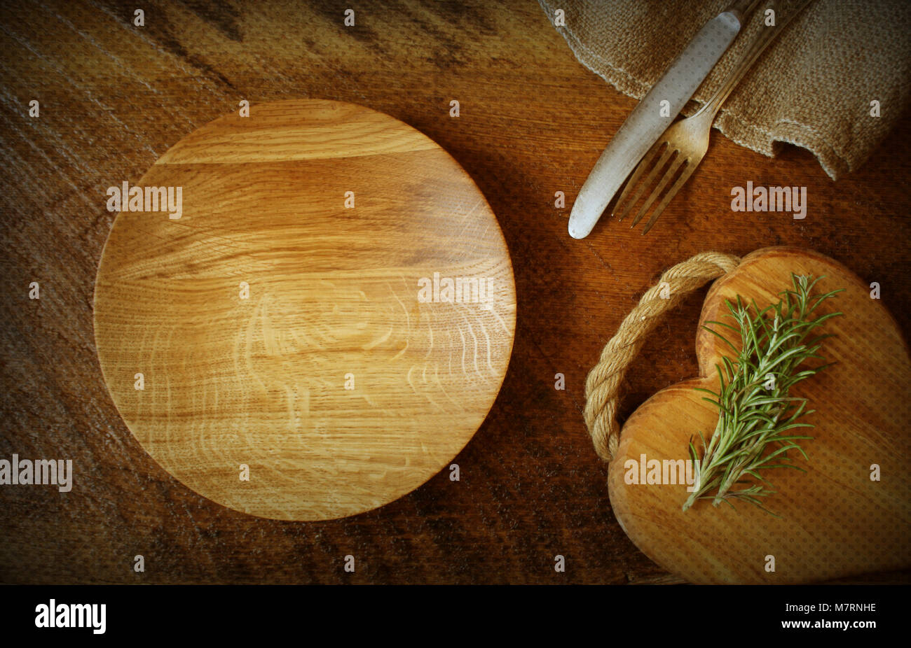 Vintage silverware, cutting board, plate, rosemary on rustic wooden ...