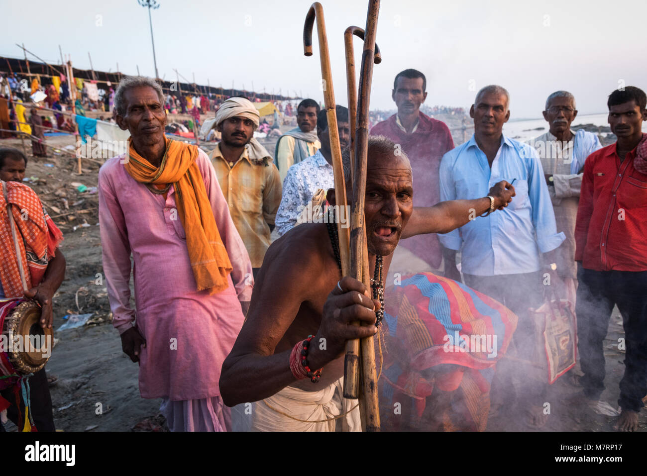 Holy man chanting and praying as others look on at the Kartika Purnima ...