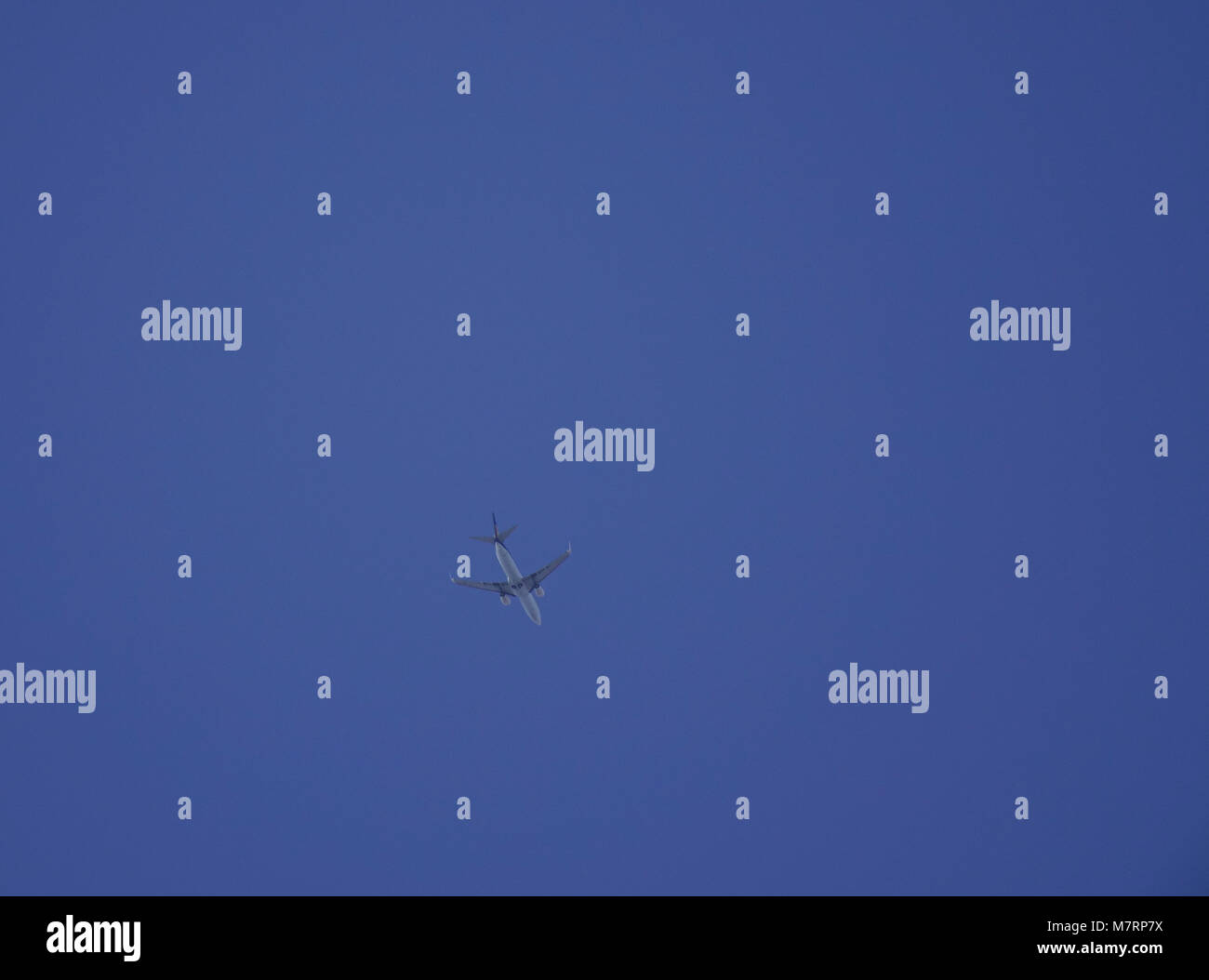 A civil aircraft flying in the blue sky at sunny day Stock Photo - Alamy