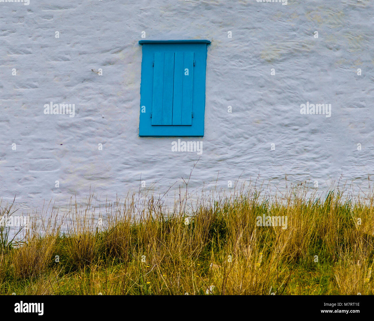 Turquoise frame wooden window on a rough whitewashed background ...