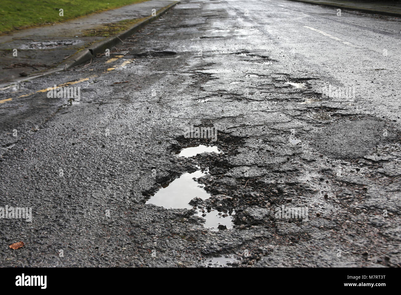 Pothole puddle on decaying tarmac road Stock Photo - Alamy