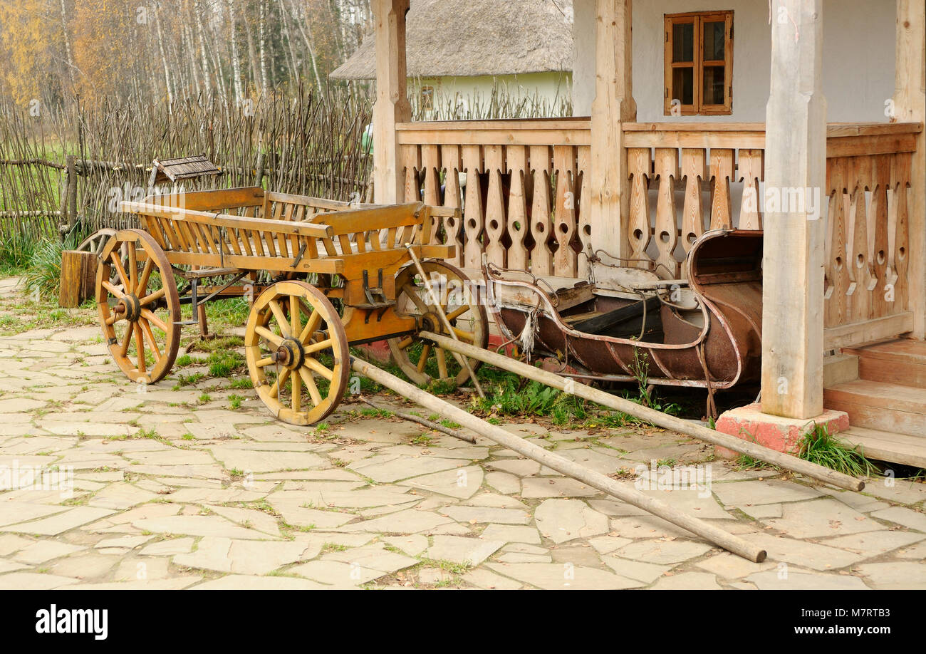 Cart and aged sledge about a porch Stock Photo - Alamy