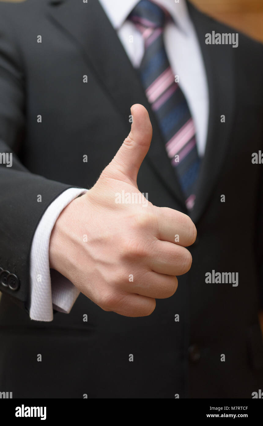 A businessman in an expensive suit makes a gesture with his hand ...