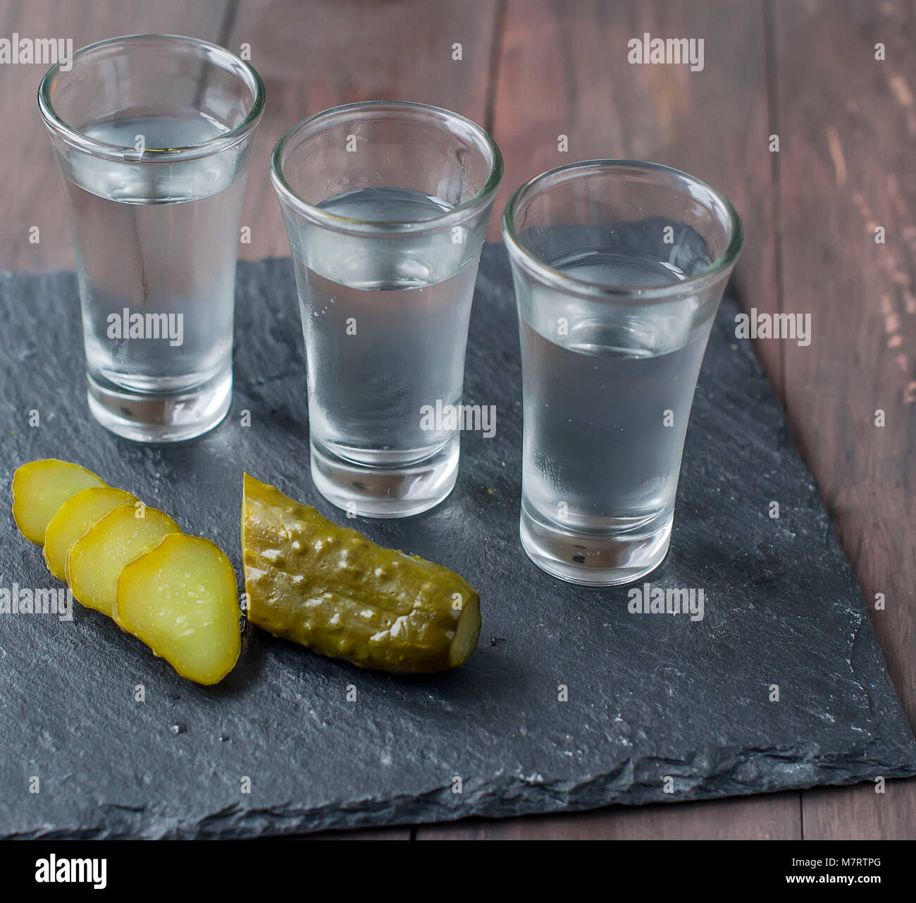 small Wine-glass of Russian vodka and salt cucumber snack on wooden ...