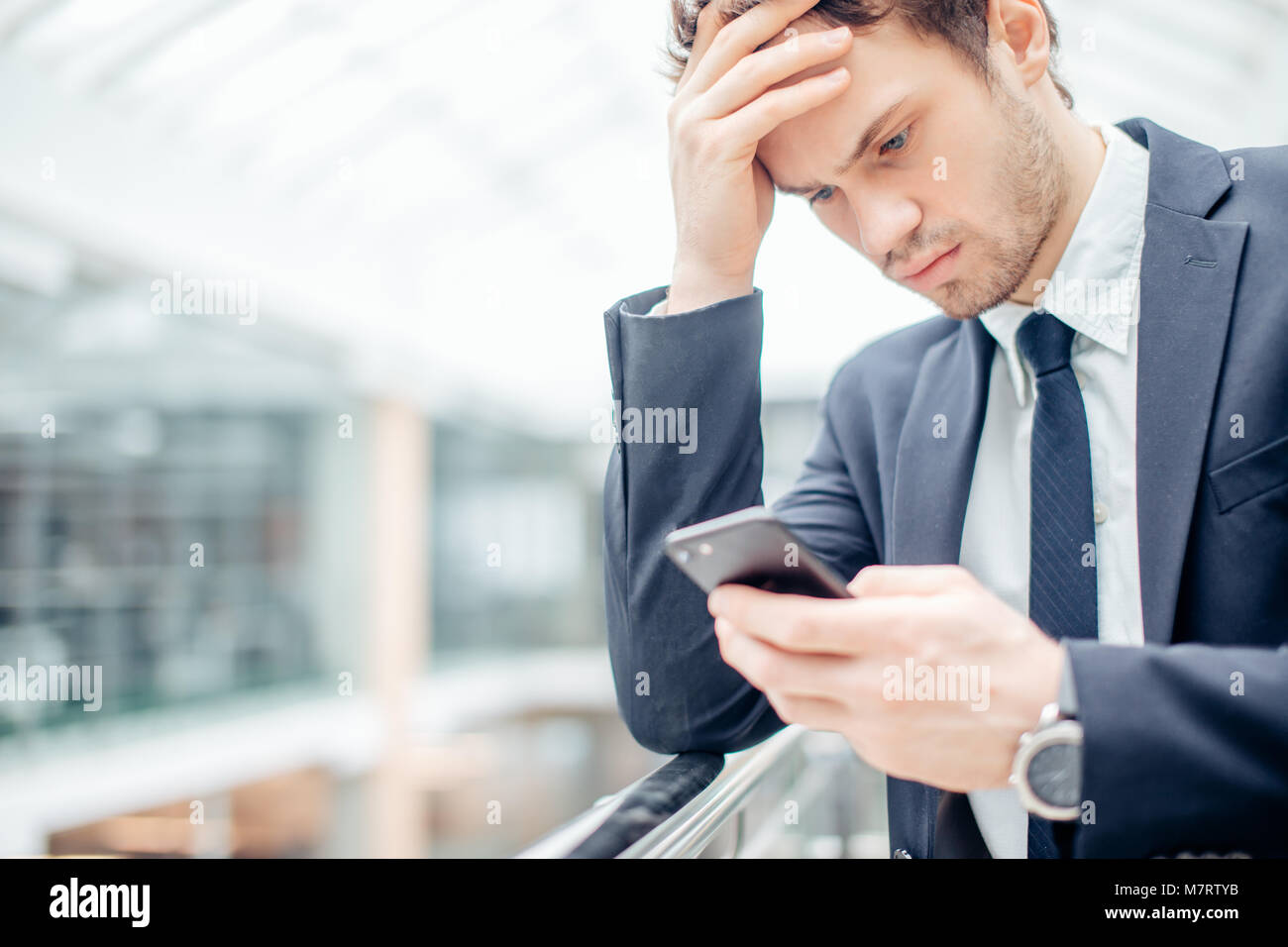 Serious man typing on smartphone. Sad man after breakup waiting for ...