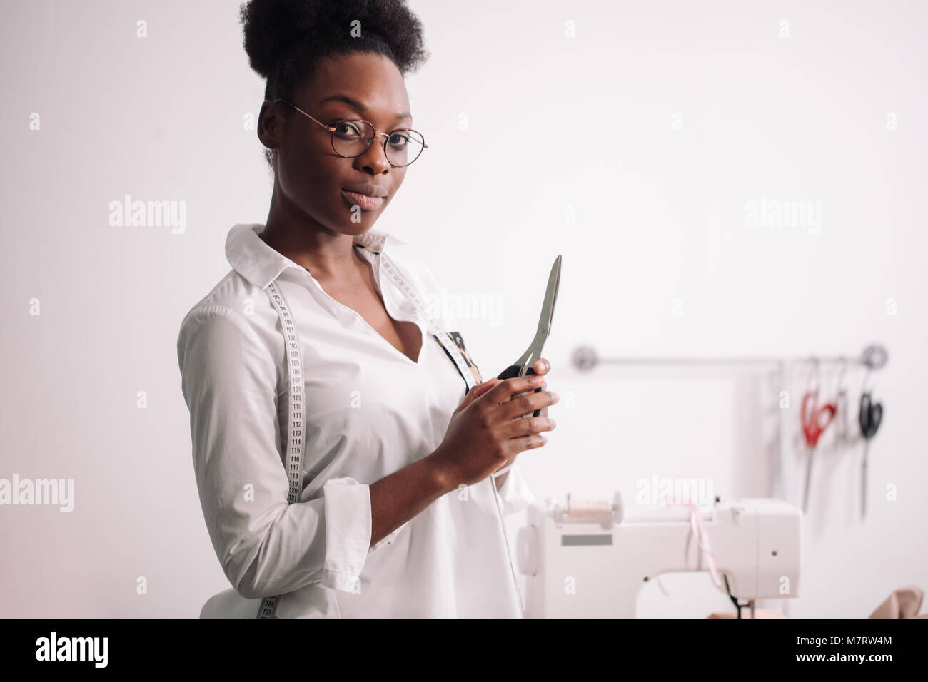 smiling african seamstress looking at camera with sewing machine Stock ...