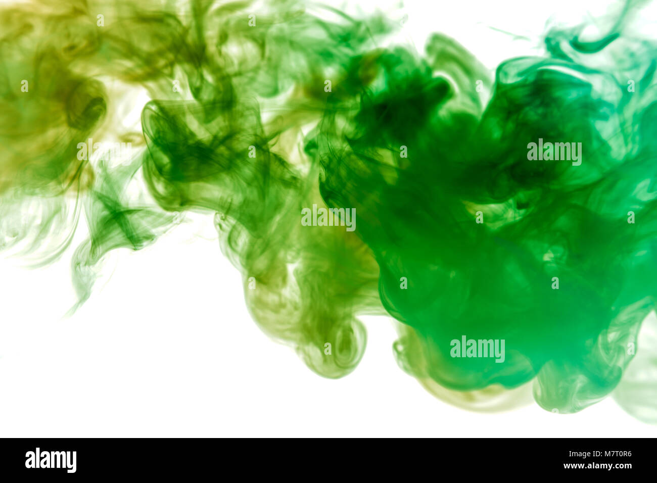 Dense multicolored smoke of green colors on a white isolated background ...