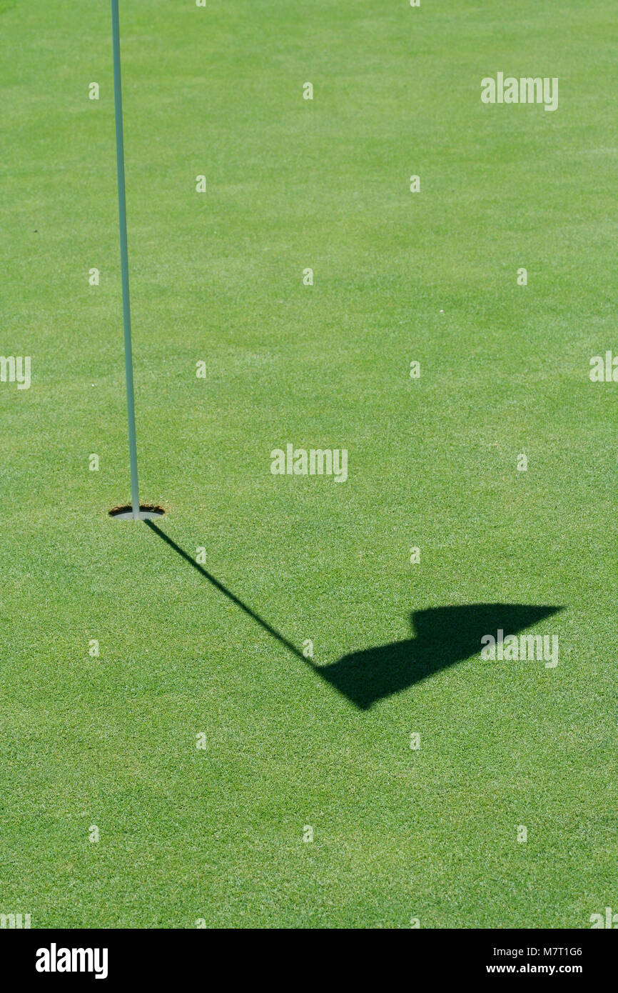 A Golf green flag shadow Stock Photo - Alamy