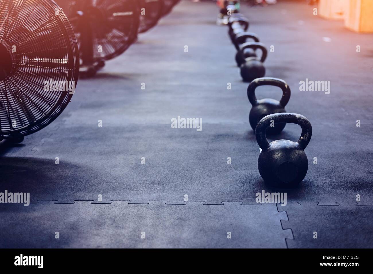 Metal heavy kettlebell weights on the gym floor Stock Photo - Alamy
