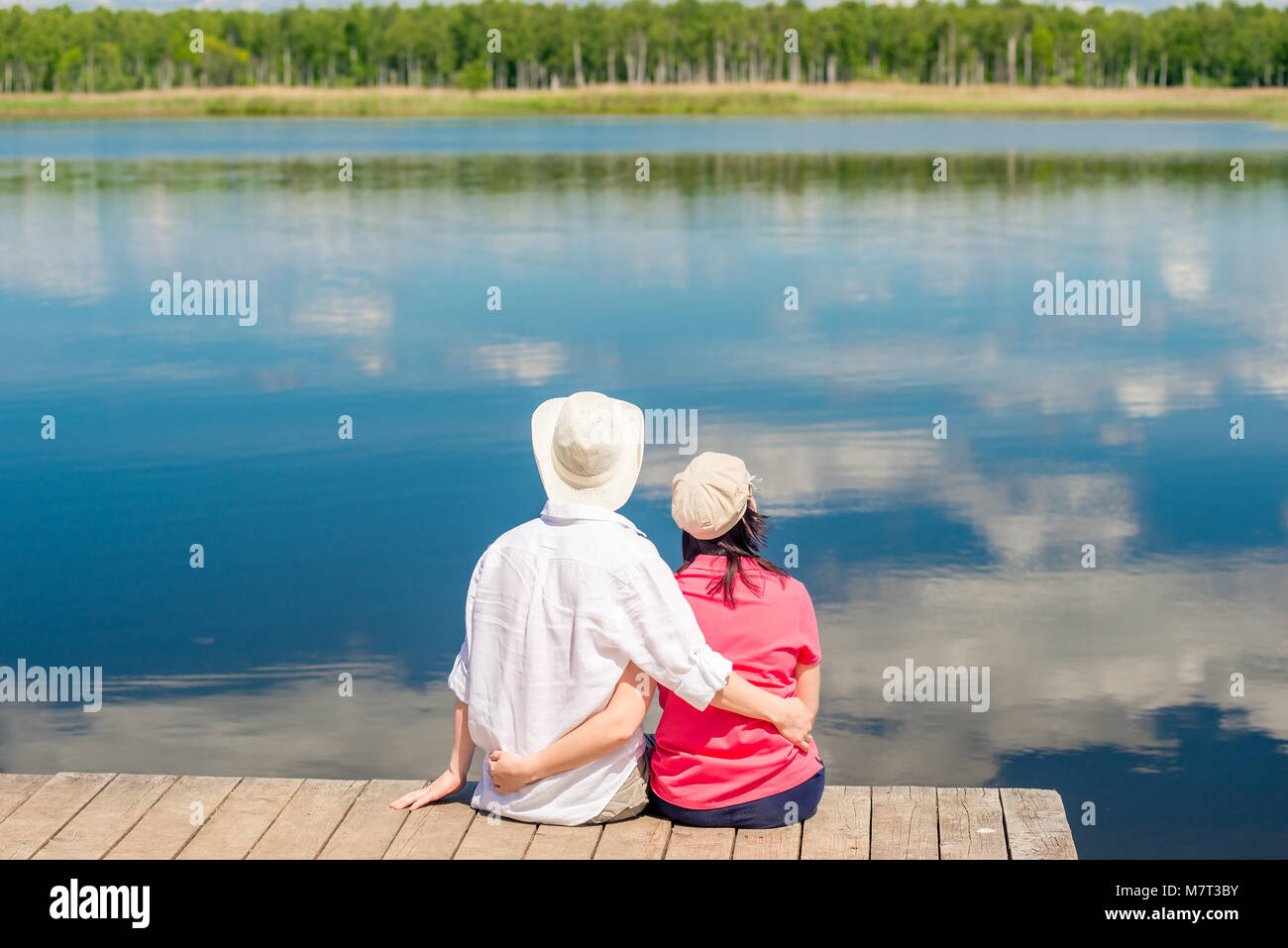 young happy couple hugging and enjoying rest near beautiful lake, view ...