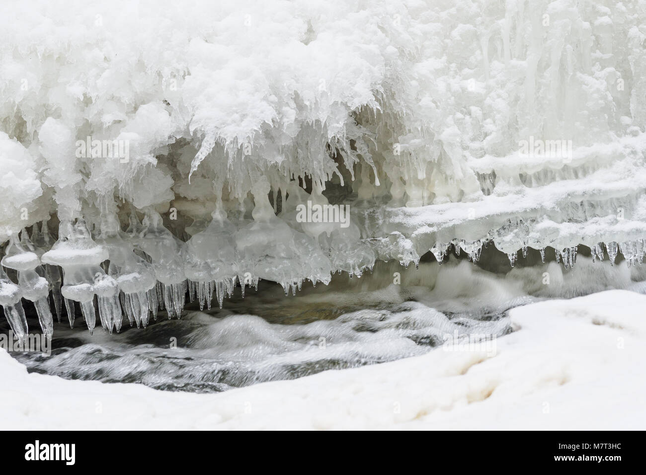 Little cascade with ice and icicles Stock Photo - Alamy