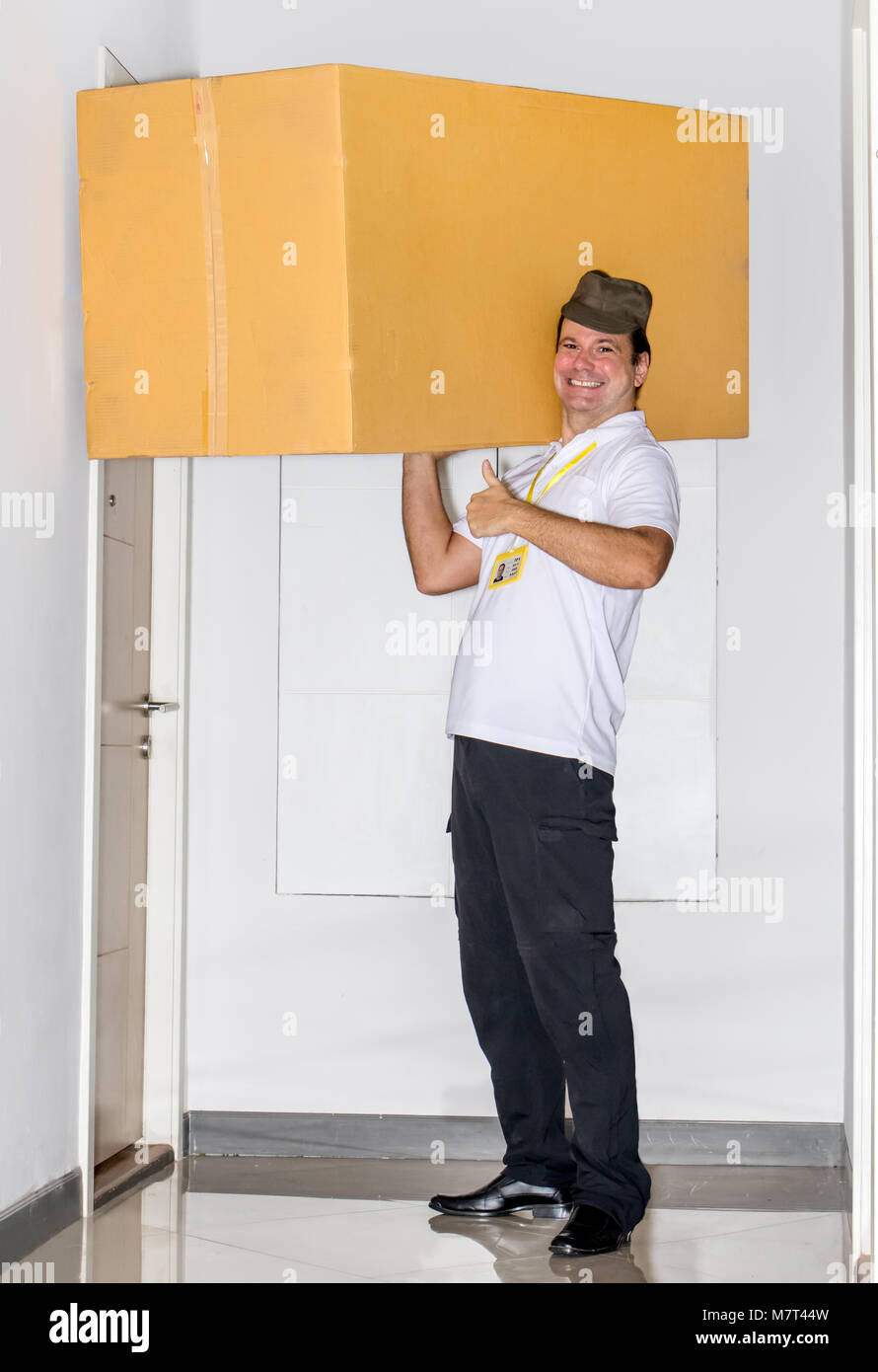 The postman carries a big package on his shoulders. The mail service ...