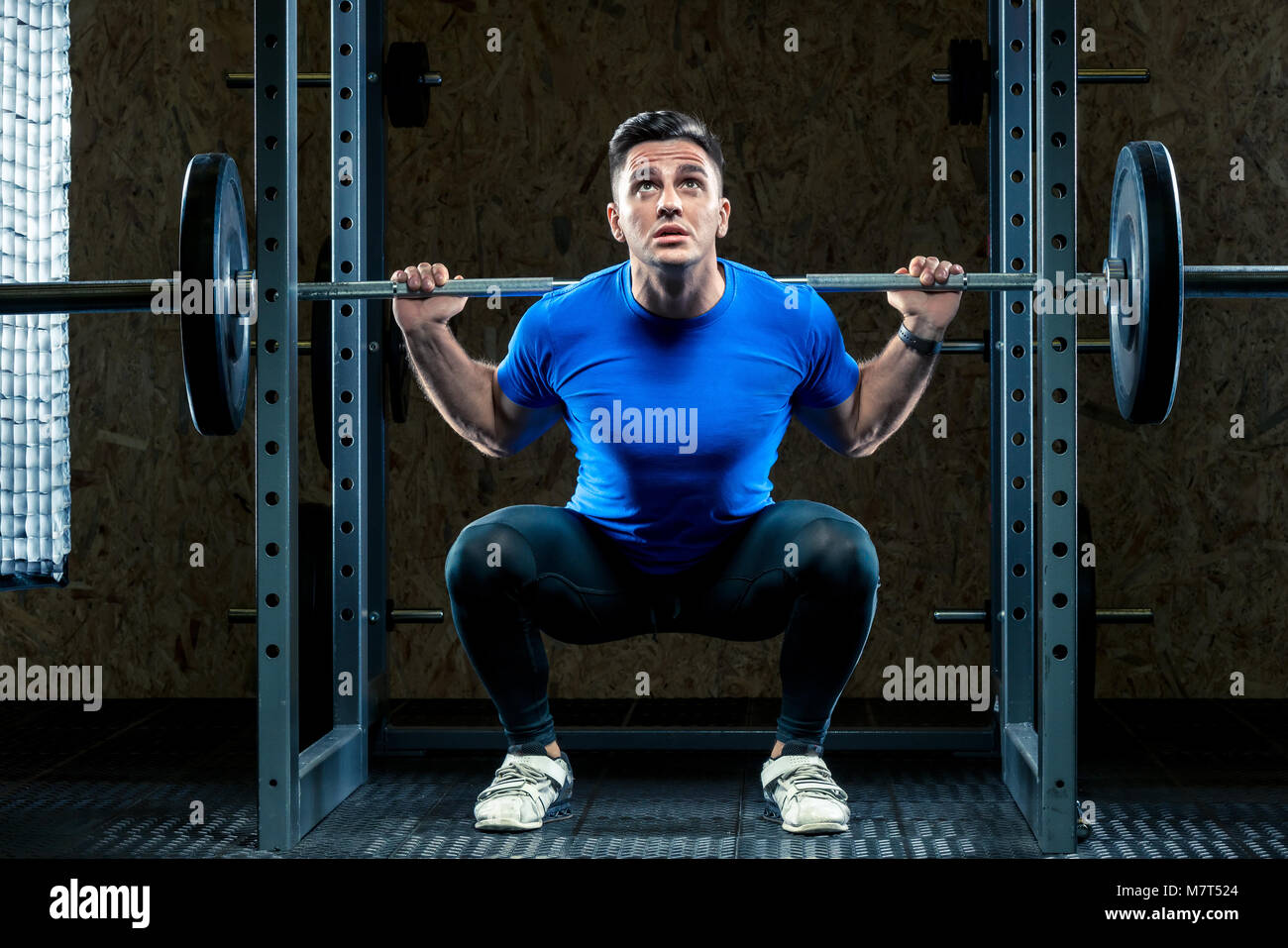 horizontal portrait of a bodybuilder with a barbell making an effort in ...