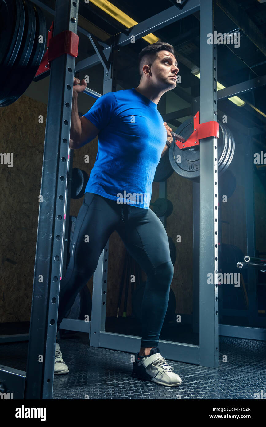 portrait of a bodybuilder with a barbell in the gym during training ...