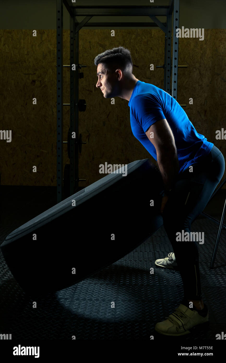 bodybuilder lifts a heavy wheel in the gym Stock Photo - Alamy