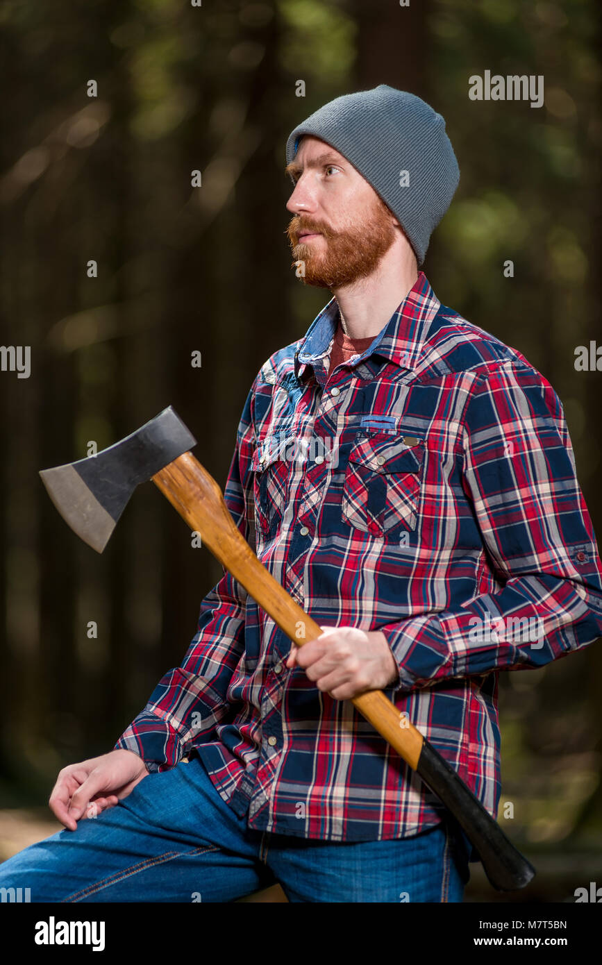 vertical portrait of a lumberjack with an ax in the summer forest Stock ...