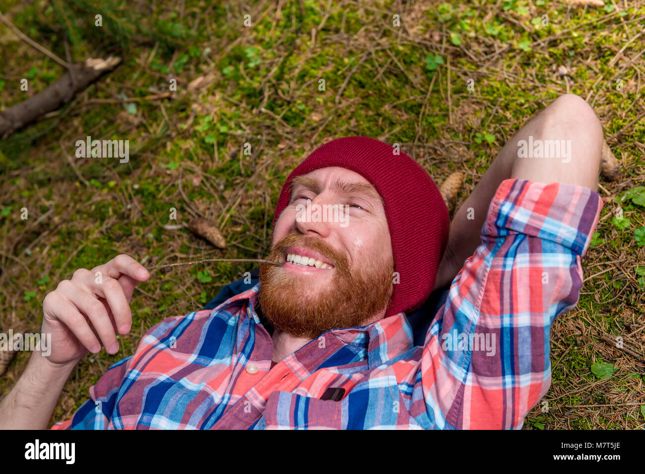close-up portrait of a happy man with a beard lying on the ground in ...
