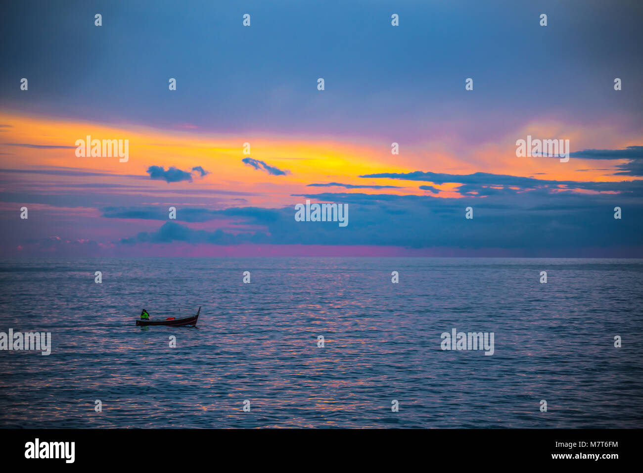 Small boat on the sea with sunset sky Stock Photo - Alamy