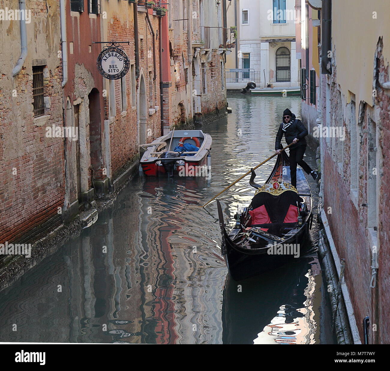 Venice, Italy - January 23, 2018. Gondoliere driving red gondola in ...