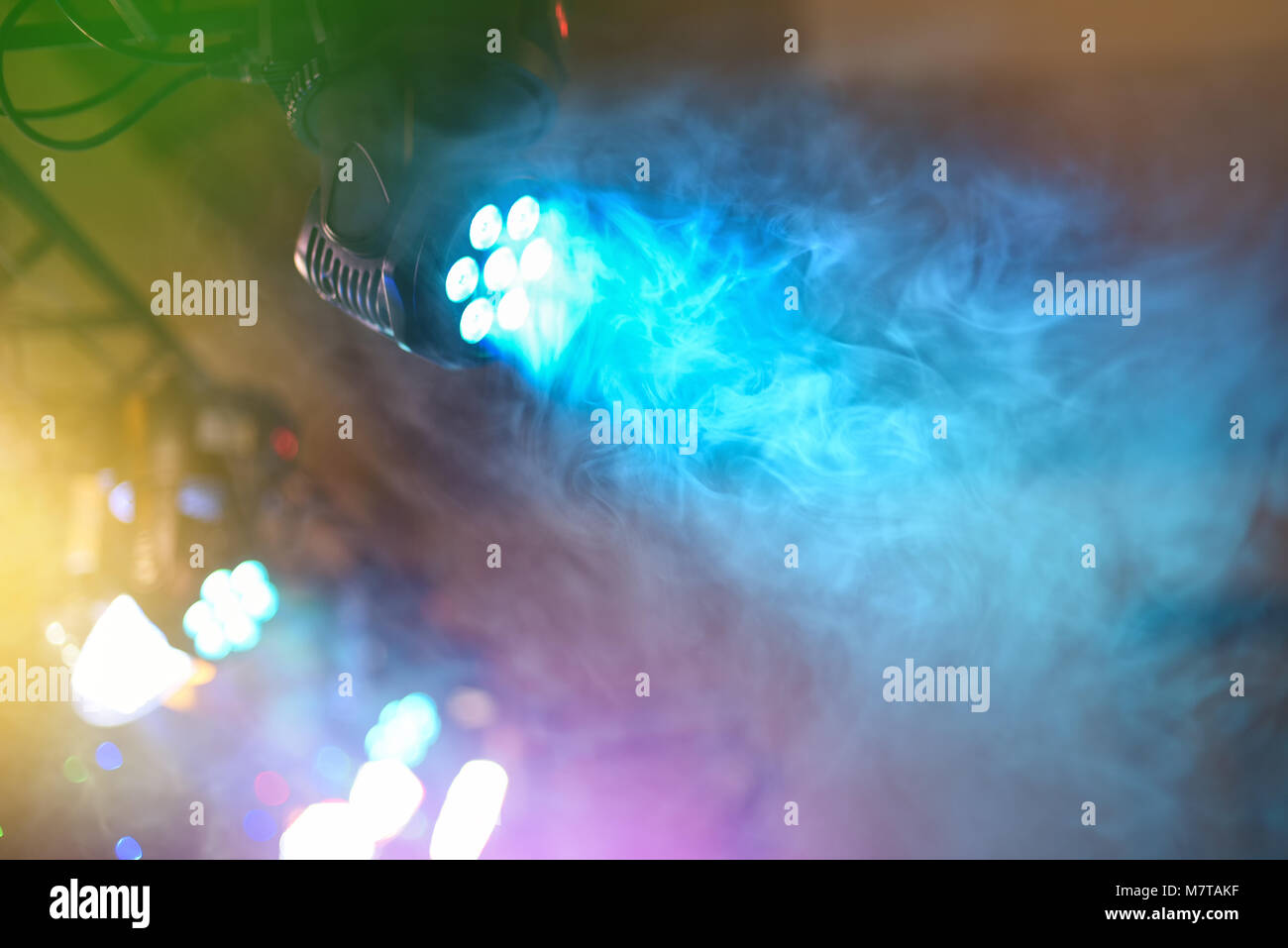 The color LED spotlight shines through dispersing smoke, entertainment ...