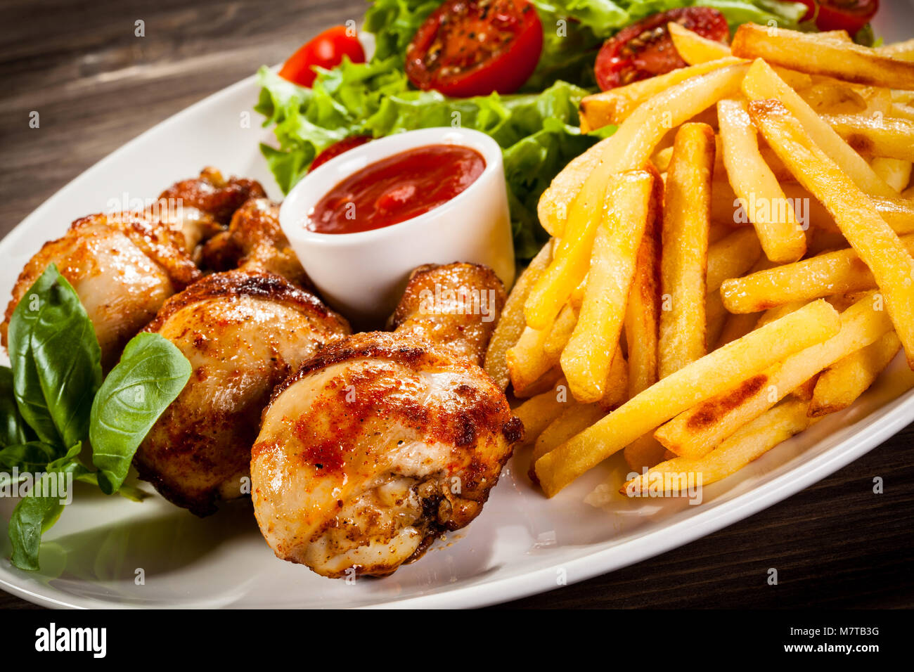 Roast chicken legs with chips and vegetables Stock Photo - Alamy
