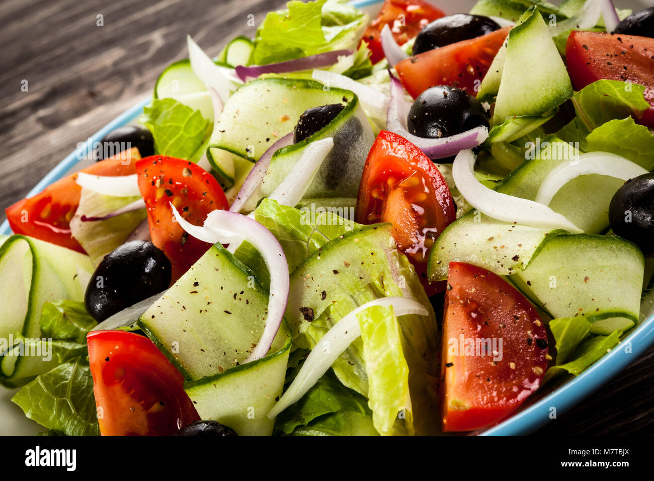 Greek salad on wooden background Stock Photo - Alamy