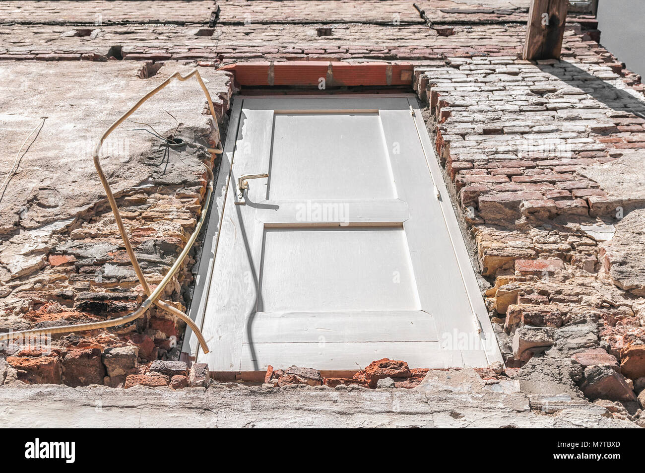 a door visible in a stone wall that is being demolished Stock Photo - Alamy